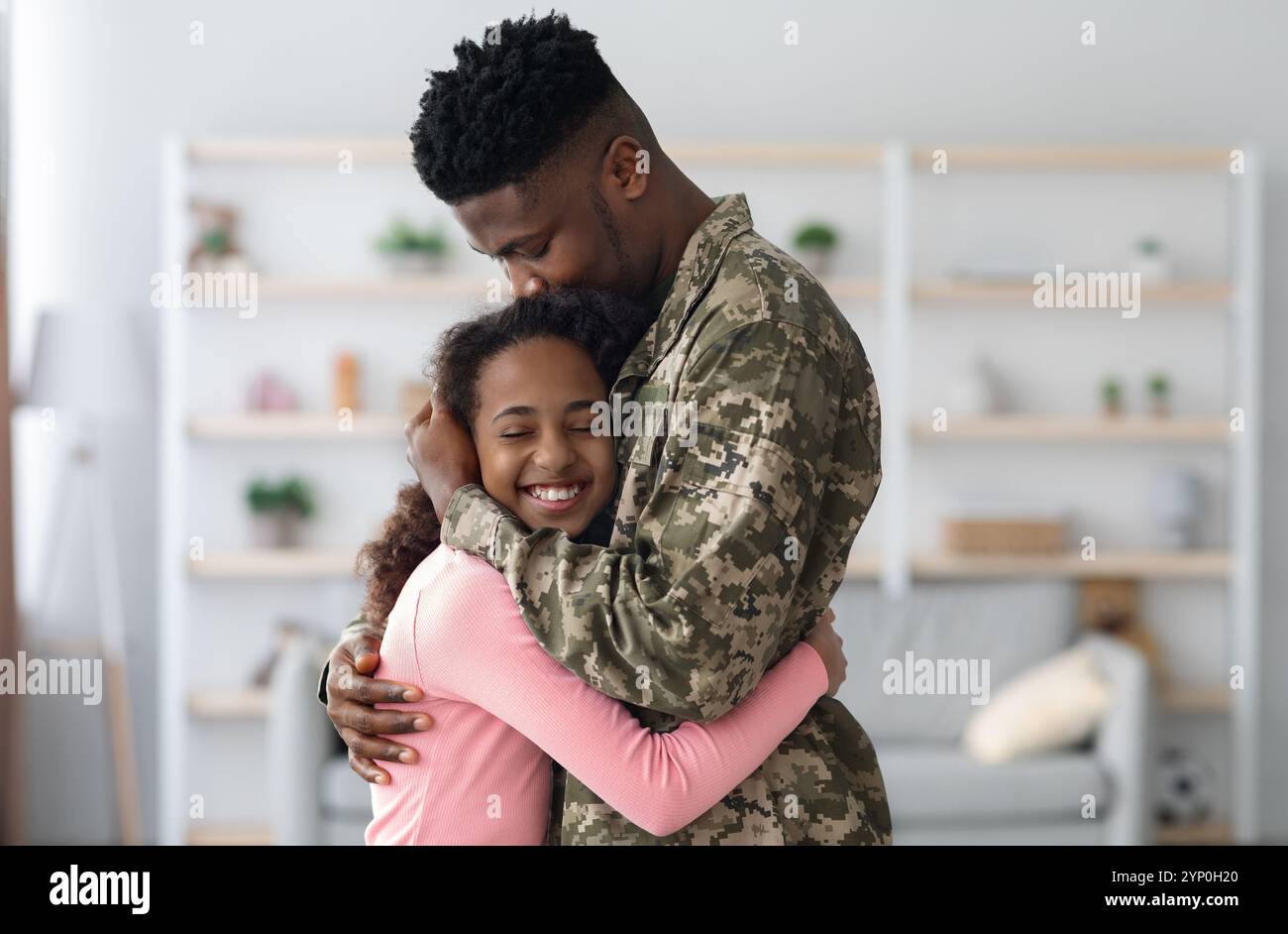 Side view of man in military uniform hugging child Stock Photo - Alamy