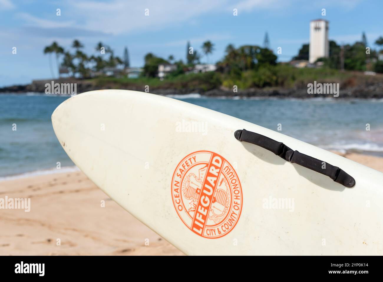 Lifeguard surfboard resting on the beach with a scenic hawaiian ...