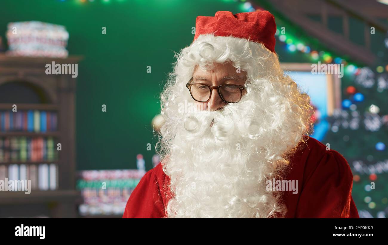 Santa Claus in his red suit browses webpages in his North Pole workshop ...