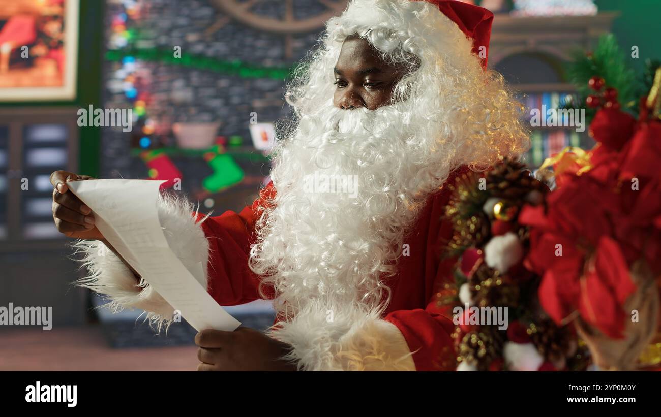 Black Santa opening and reading letters sitting cozy in his log cabin ...