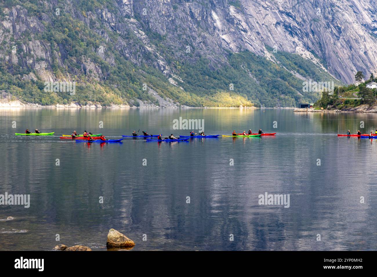 Eidfjord Norway, tour group in kayaks paddle on the fjord, Eidfjord is ...