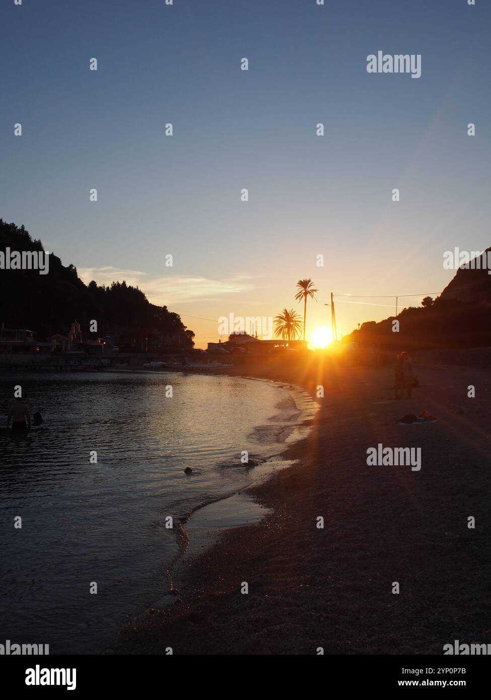 Vertical picture of the Sun setting on a beach in Corfu, Greece Stock ...