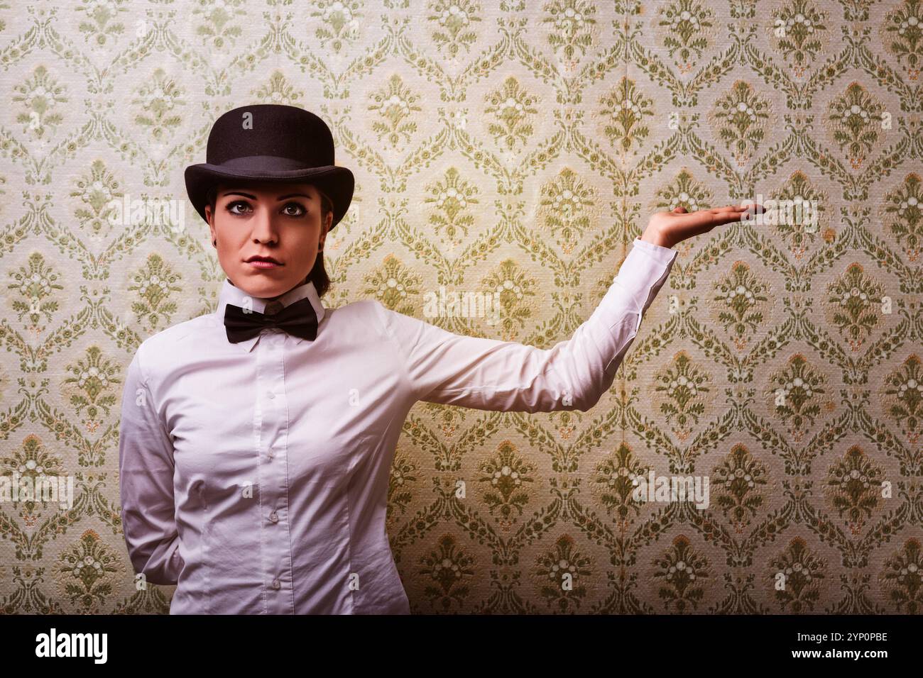Young woman with serious expression wearing white shirt, black bowler ...