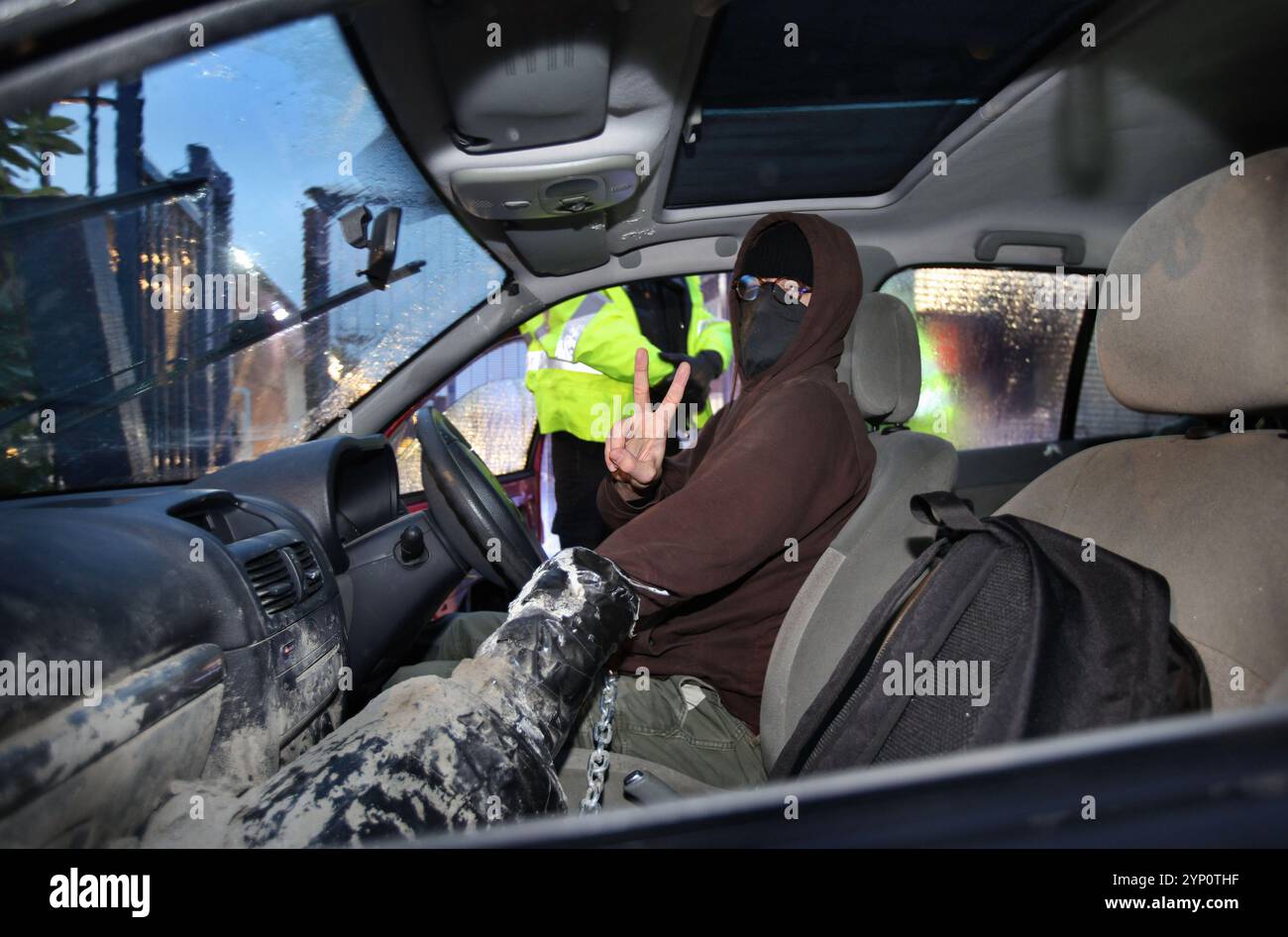 An actionist shows a peace sign with their hand, one of their arms is ...