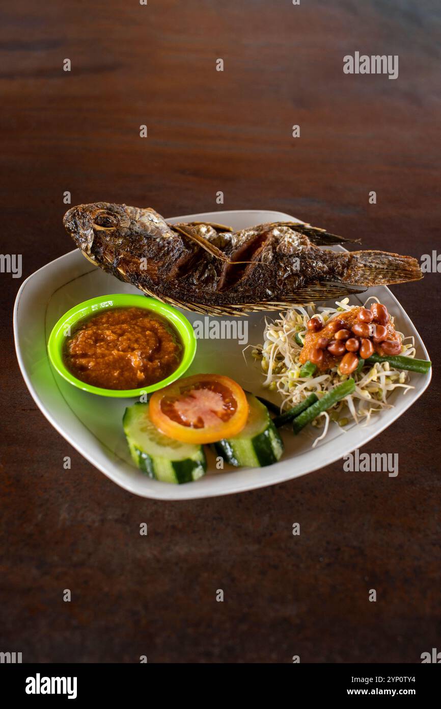 A lunch set menu featuring fried fish, sambal (chili sauce), slice of ...
