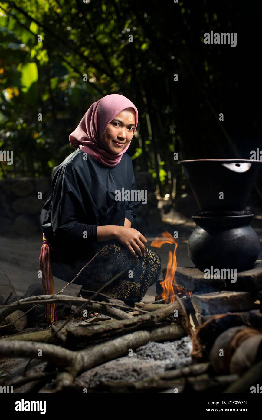 A woman steaming rice using a traditional cooking method, Lombok, West ...