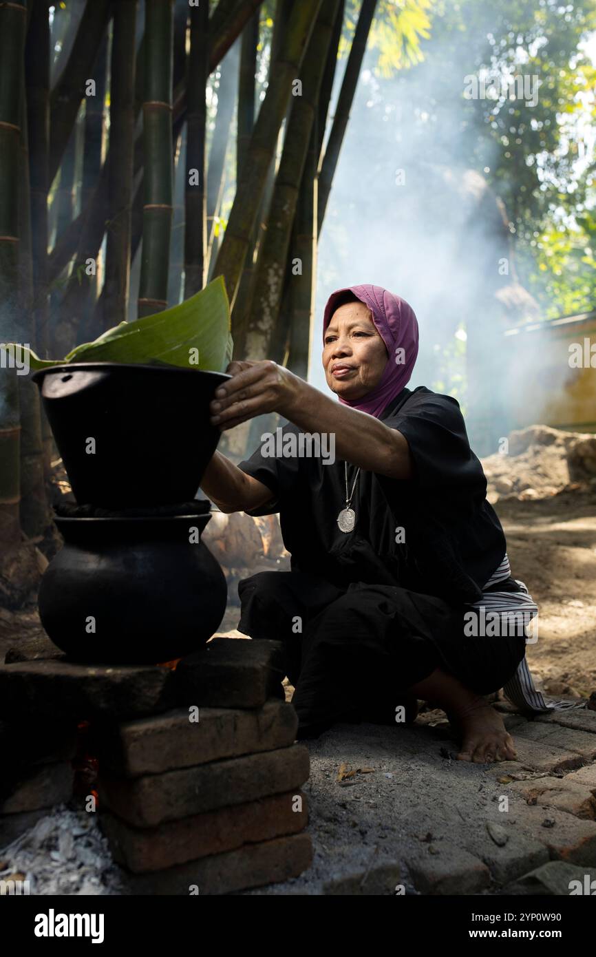 A woman steaming rice using a traditional cooking method, Lombok, West ...
