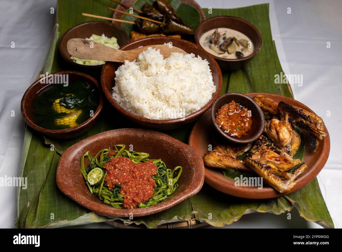 A lunch set menu featuring steamed rice, fried chicken, vegetable soup, and sambal (chili sauce ...