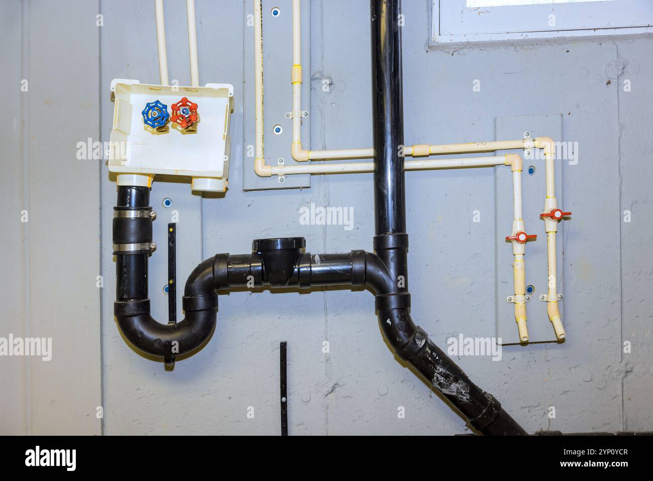 Plumbing setup featuring black, pipes connected to valve control panel ...