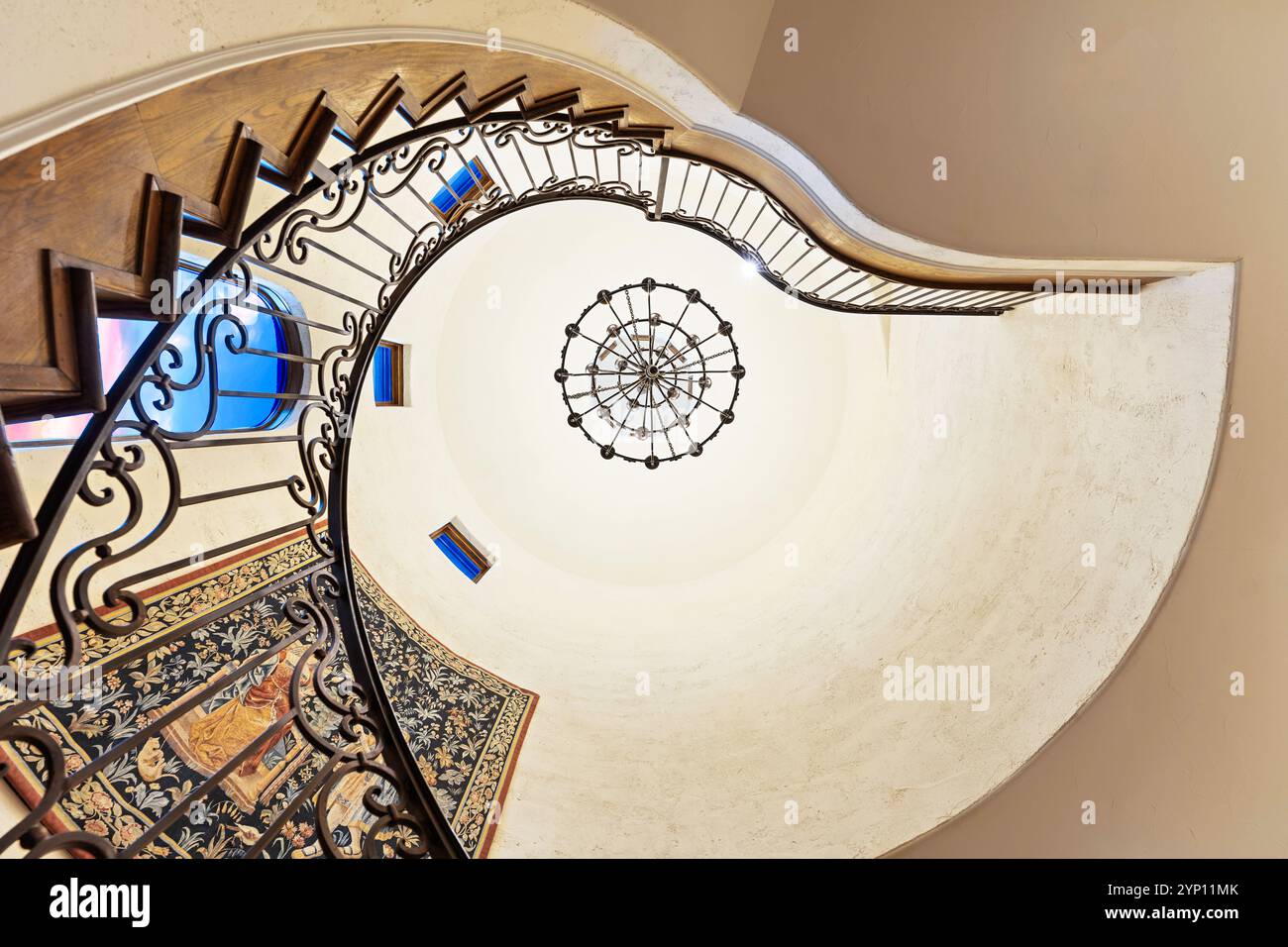 Elegant spiral staircase with intricate railing and chandelier Stock Photo - Alamy