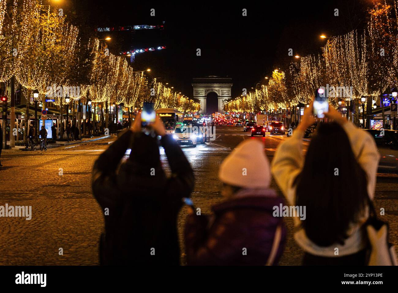 Paris, France. 26th Nov, 2024. People take photos of the Champs-Elysées ...
