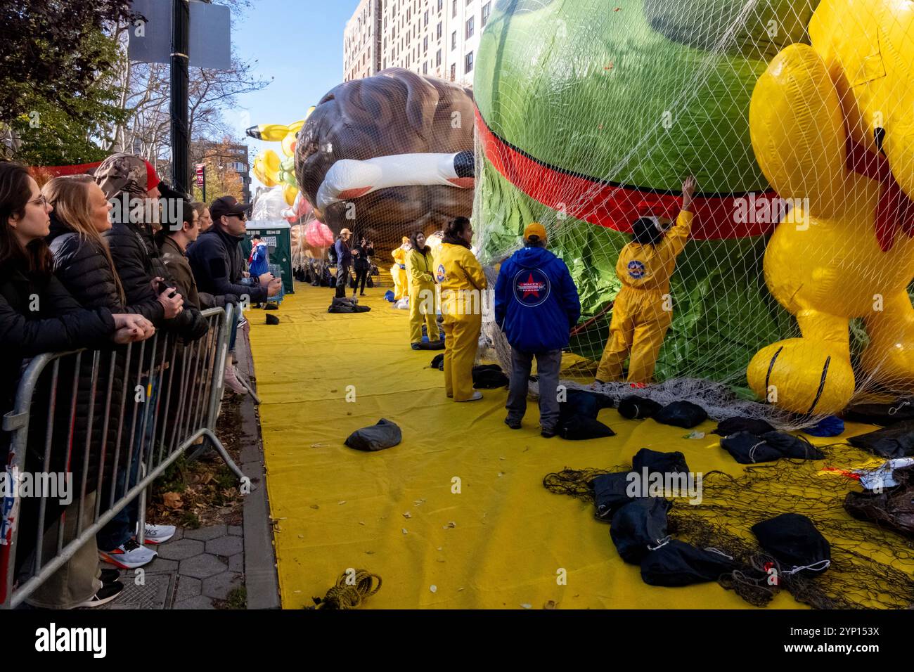 Crowds watch as the balloon team work on inflating Snoopy. Every year ...