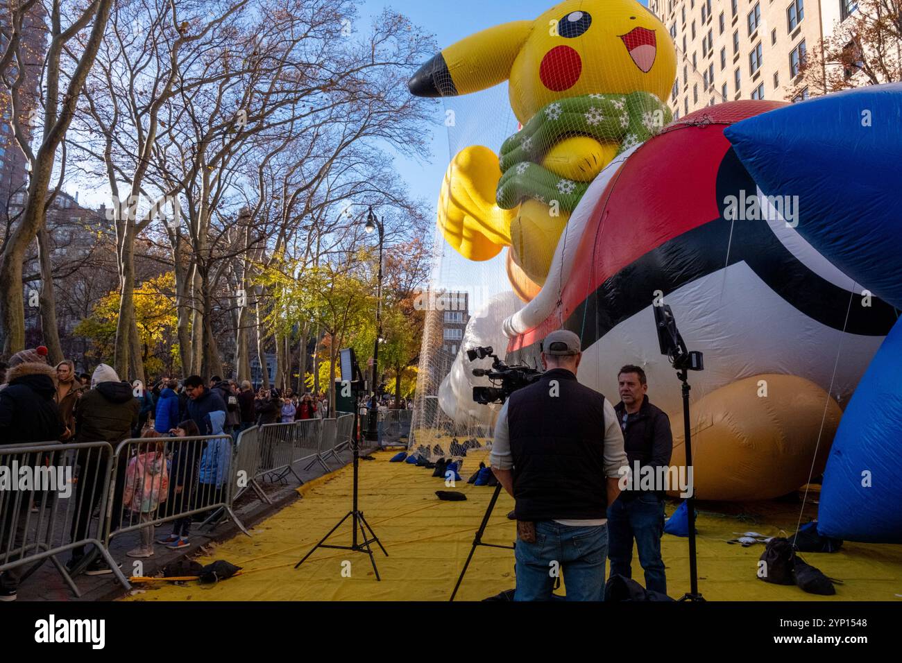The Pokeman Pikachu balloon dwarfs the crowd and TV crew on 81st Street ...