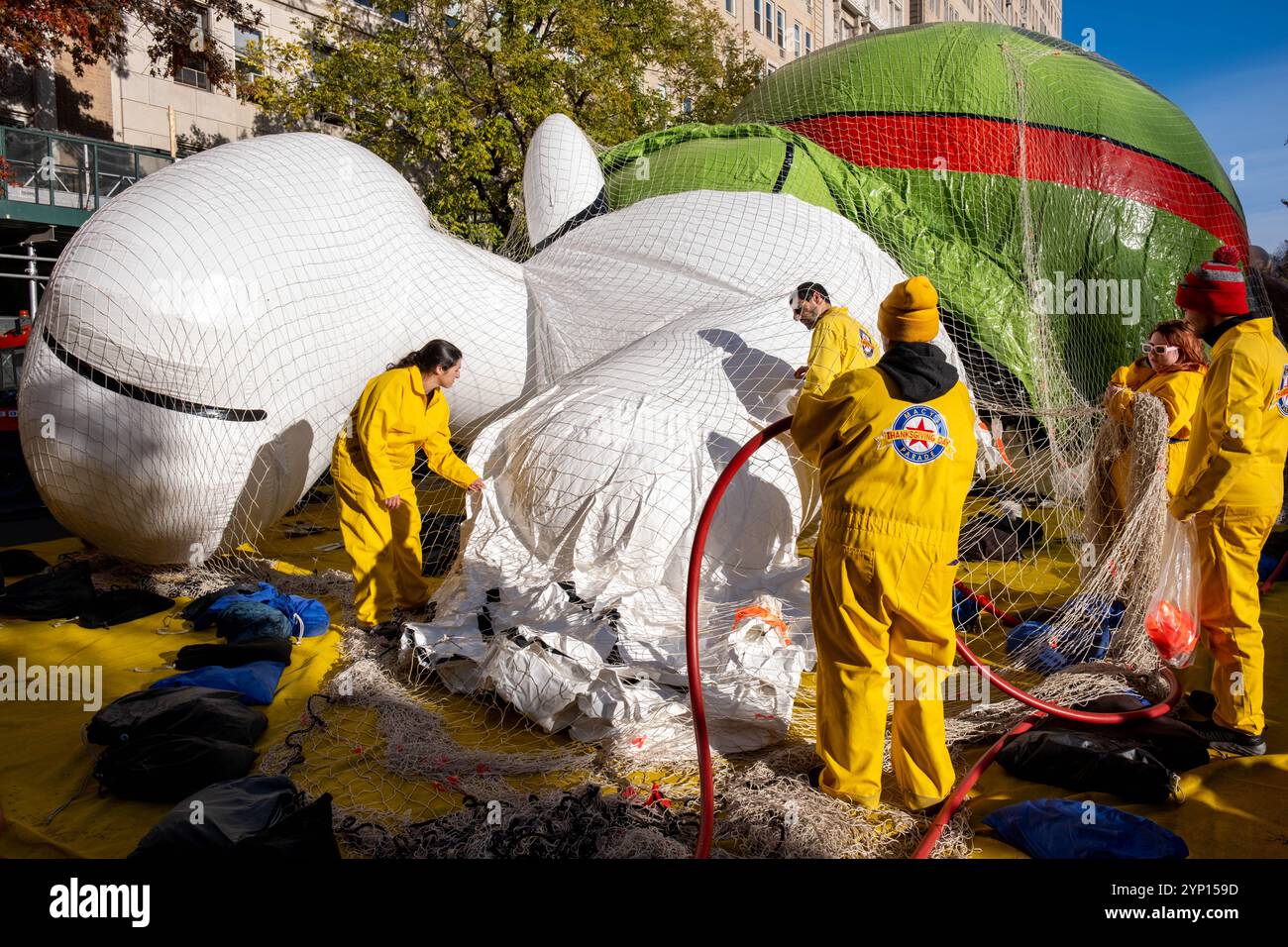 A balloon team dressed in yellow work on inflating Snoopy. Every year ...