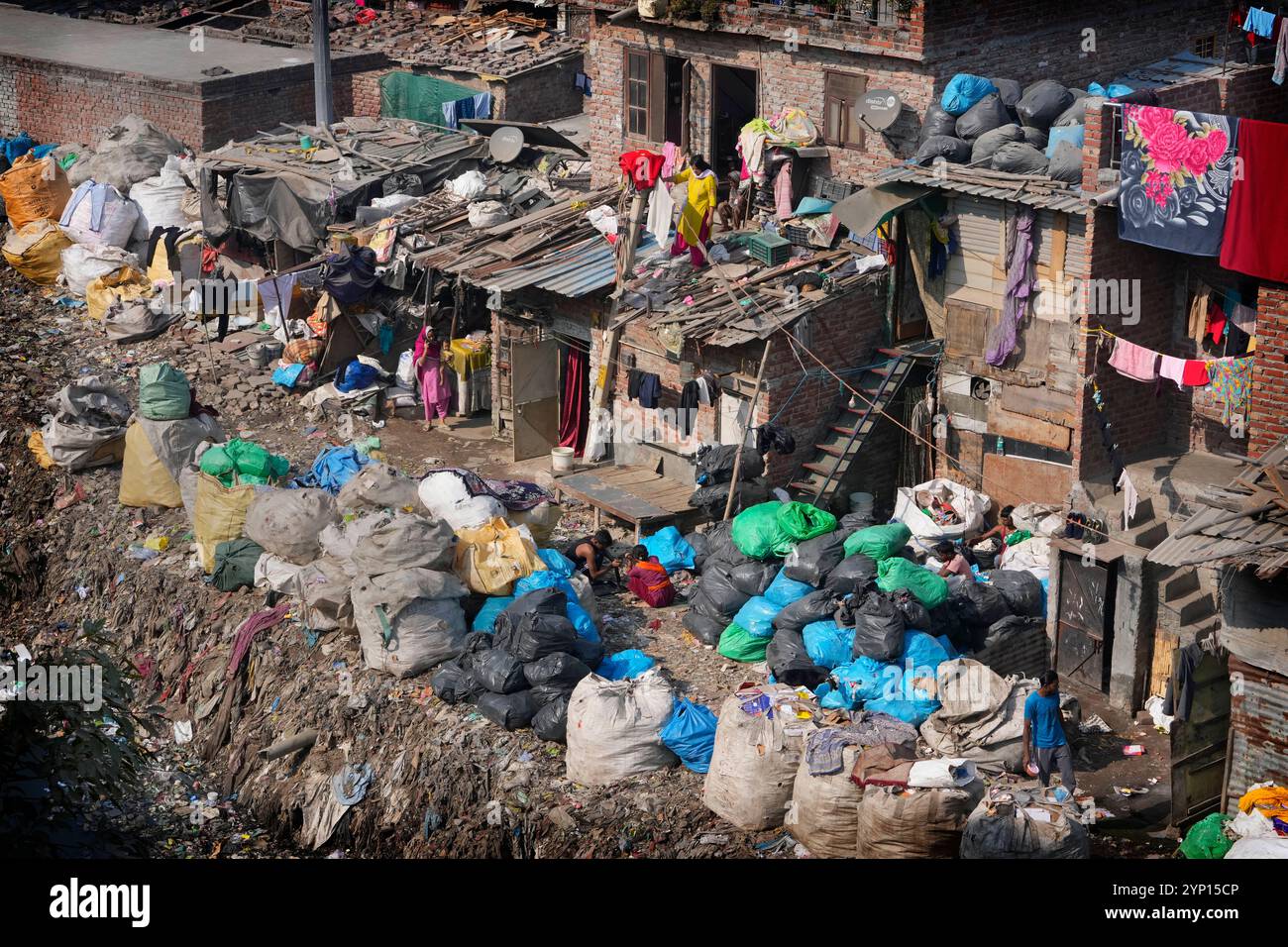People store various waste materials in plastic sacks for sorting out ...