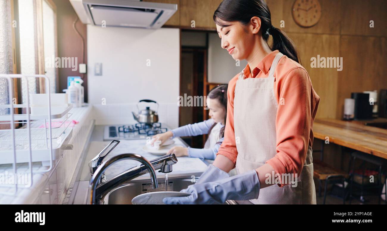 Mom, girl and washing dishes in home with smile, learning and helping ...