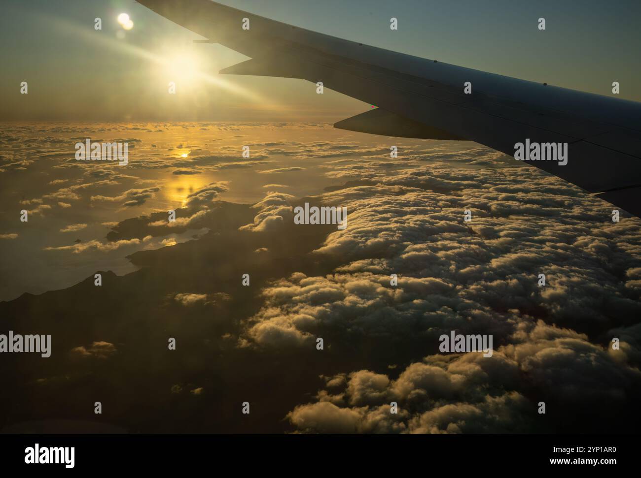 Airplane window view of the sun rising over the clouds. Airplane flying ...