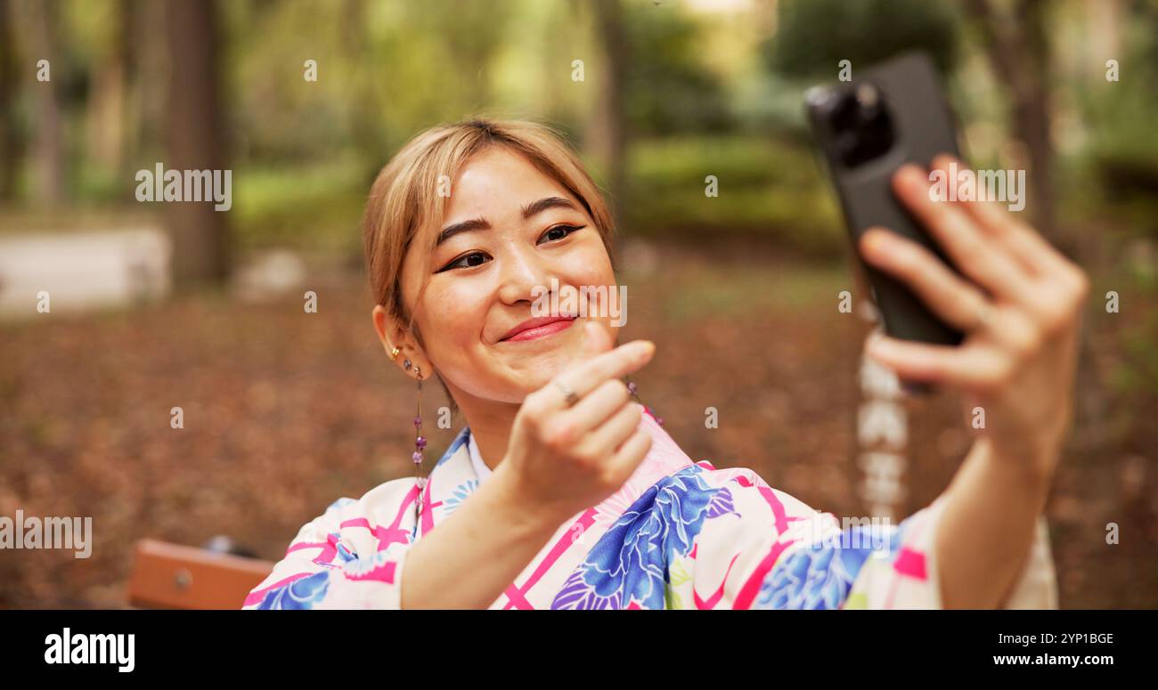 Selfie, travel and woman in nature, gesture and happy for memory on vacation, smile and kimono ...