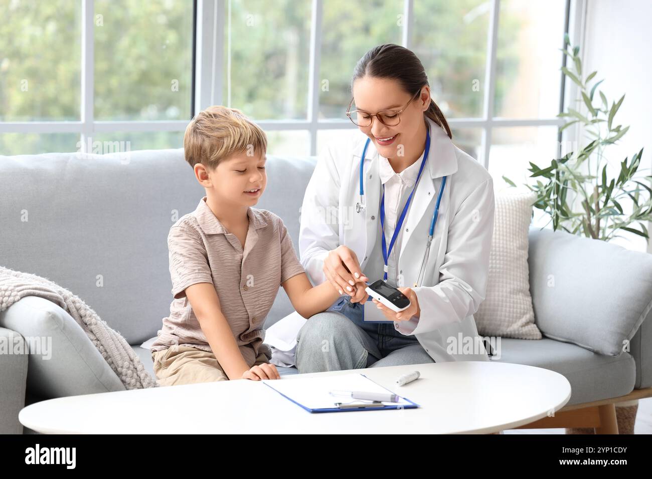 Little diabetic boy with doctor using glucometer at home Stock Photo ...