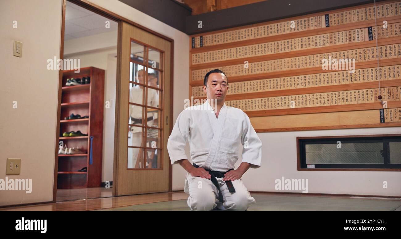 Martial arts, kneeling and Japanese man with respect, honor and karate etiquette in dojo. Japan ...