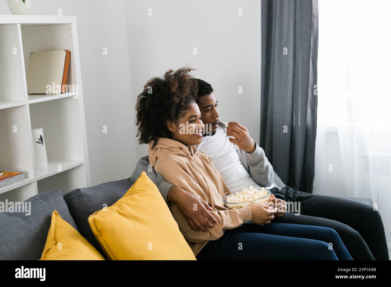 African American couple wife husband watching movie. Family pastime and leisure, watch ...