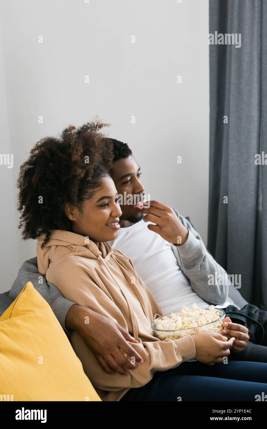 African American couple wife husband watching movie. Family pastime and leisure, watch ...