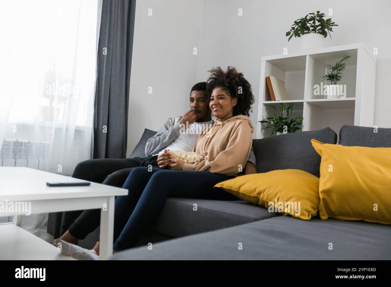 African American couple wife husband watching movie. Family pastime and leisure, watch ...