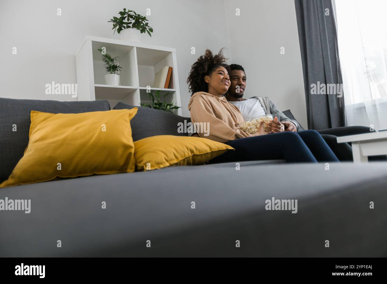 African American couple wife husband watching movie. Family pastime and leisure, watch ...