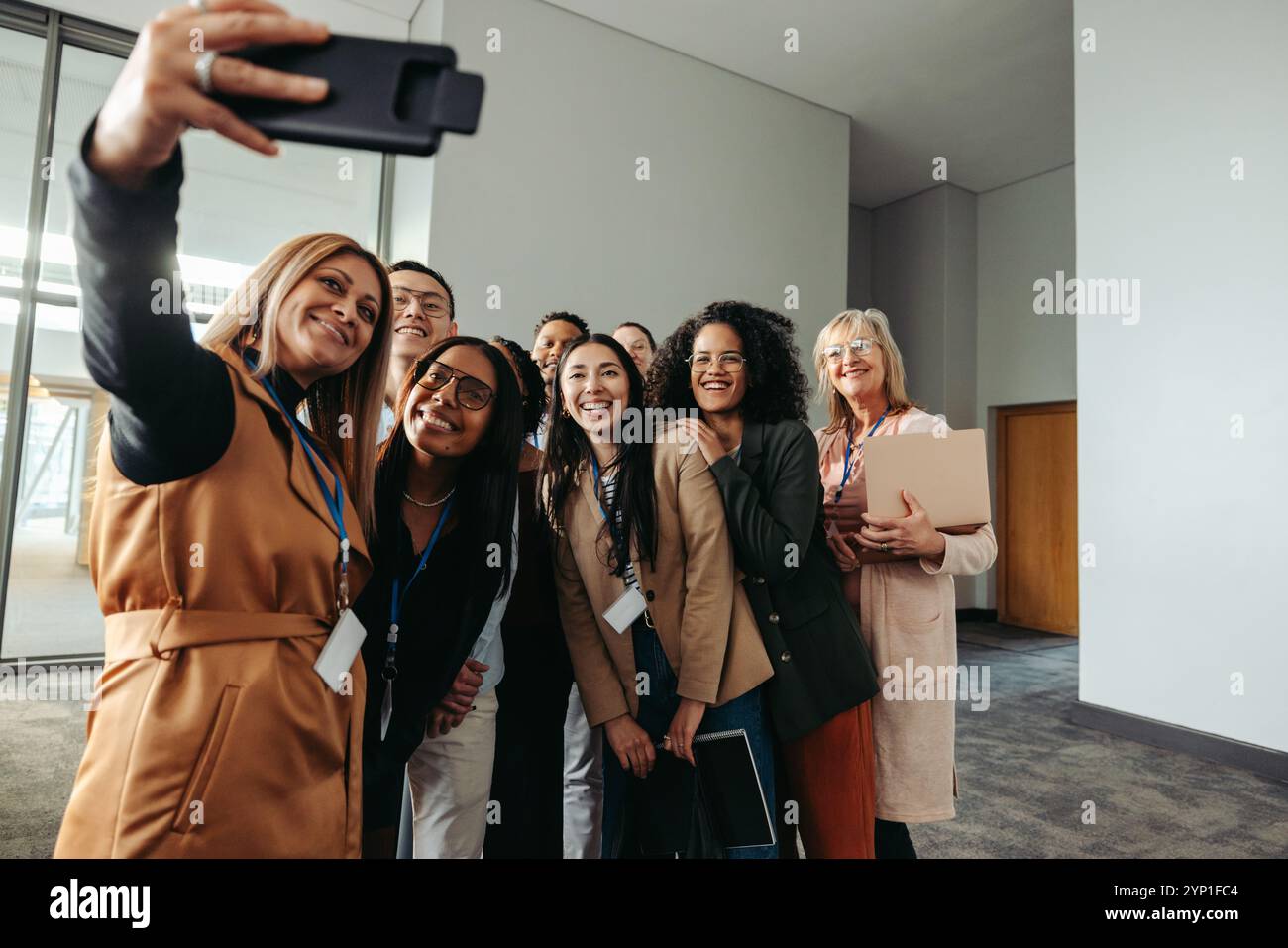 Business people taking a joyful selfie together at a networking event, showcasing teamwork and ...