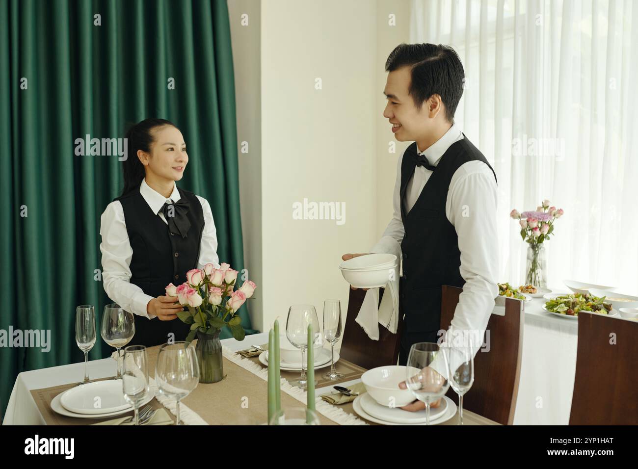Two Waitstaff Arranging Table Setting in Restaurant Stock Photo - Alamy
