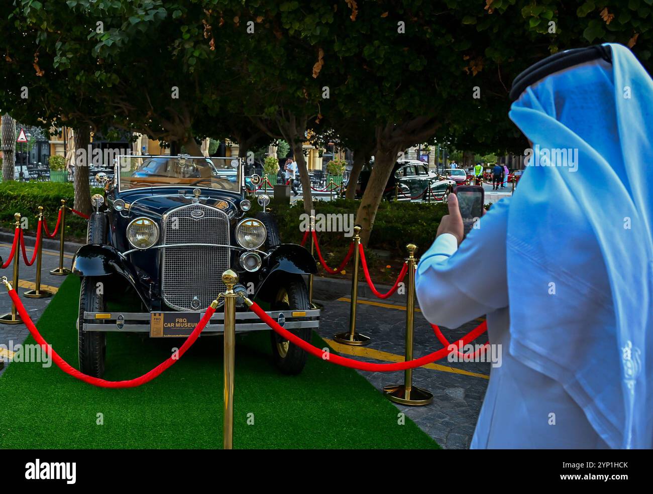 QATAR CLASSIC CARS EXHIBITION 2024 IN DOHA A Qatari man takes a photo ...
