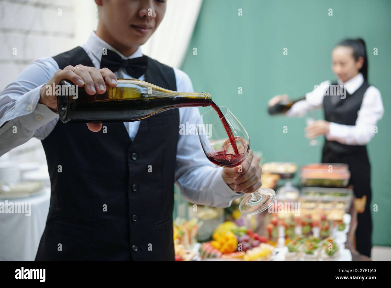 Pouring Red Wine at Elegant Outdoor Event Stock Photo - Alamy