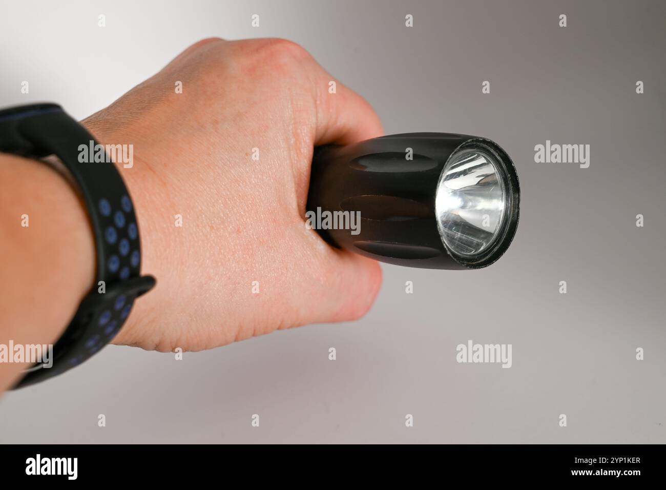 hand holding well used small but powerful flashlight or electric torch ...