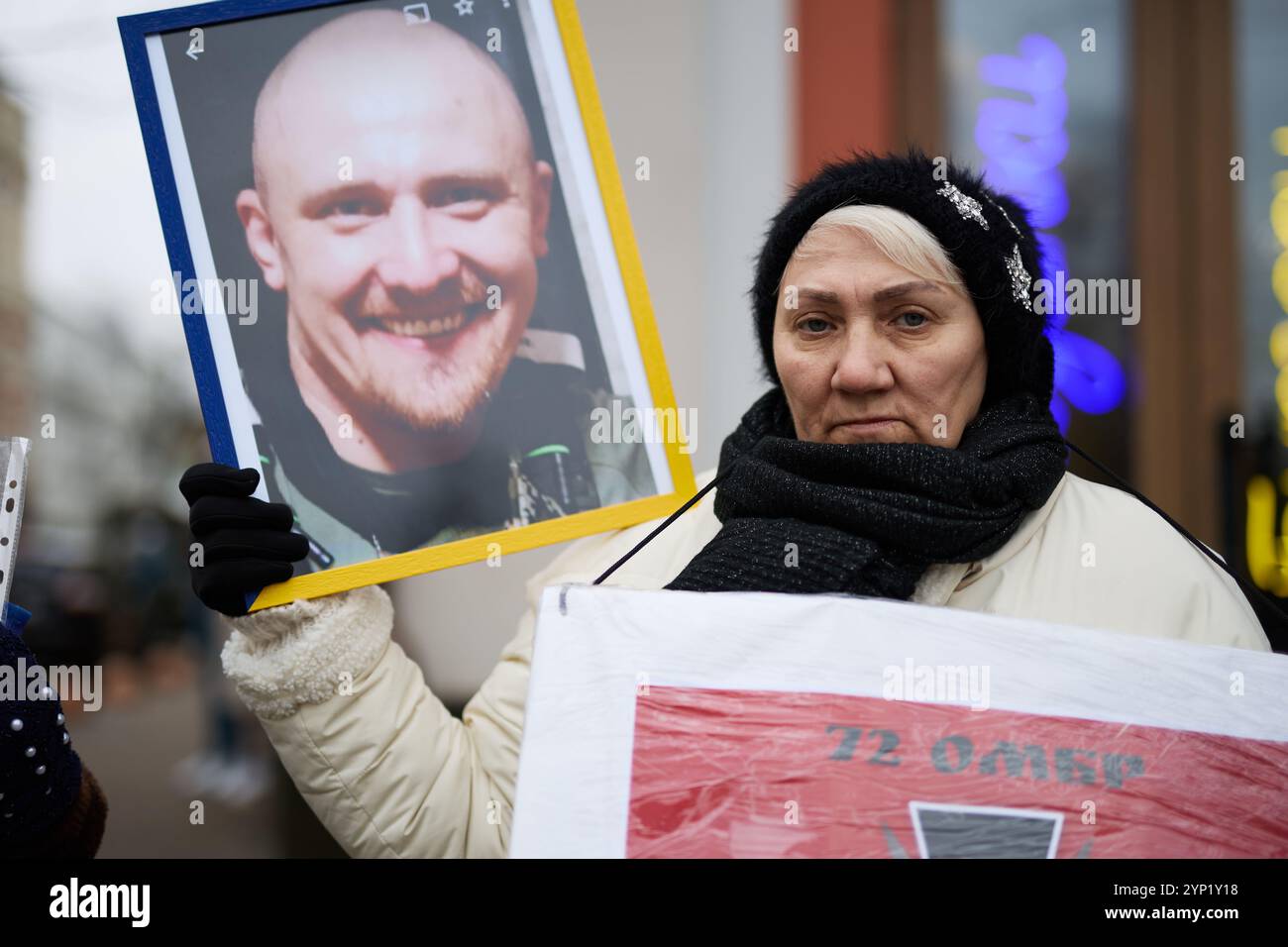 Ukrainian woman posing with a portrait of her missing son, soldier of ...