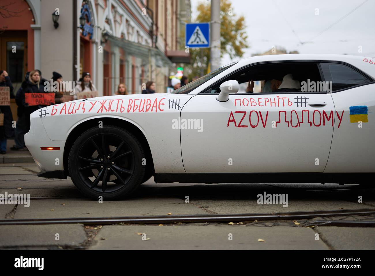 Ukrainian activist rides in a Dodge Challenger with writing "Free Azov ...