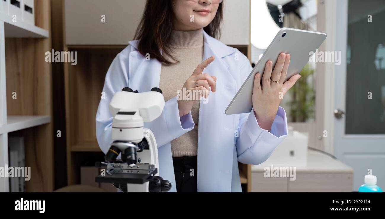 Scientist in Lab Coat Using Tablet Next to Microscope in Modern ...