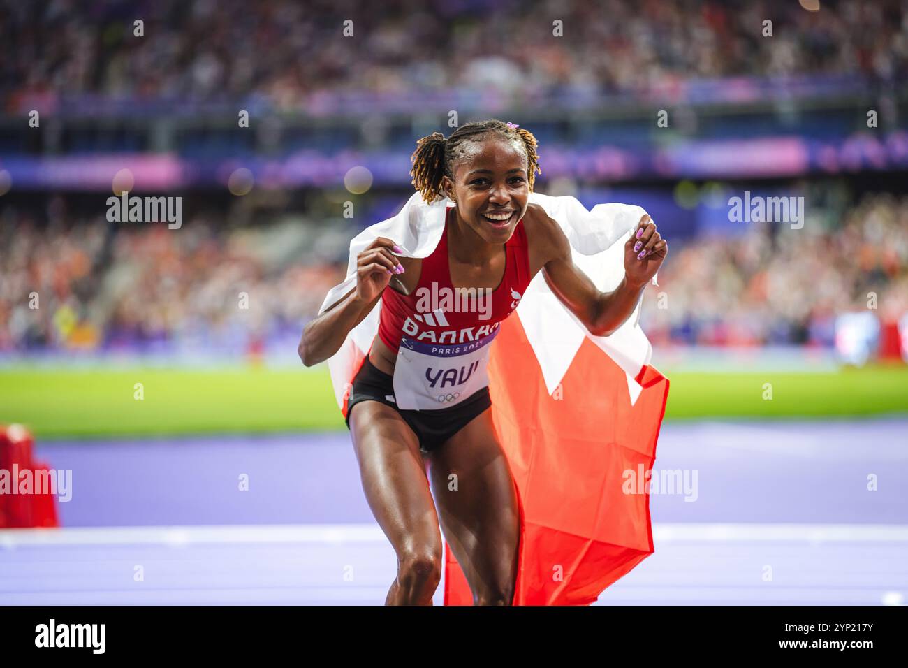 Winfred Yavi celebrating her medal with her country's flag at the Paris ...