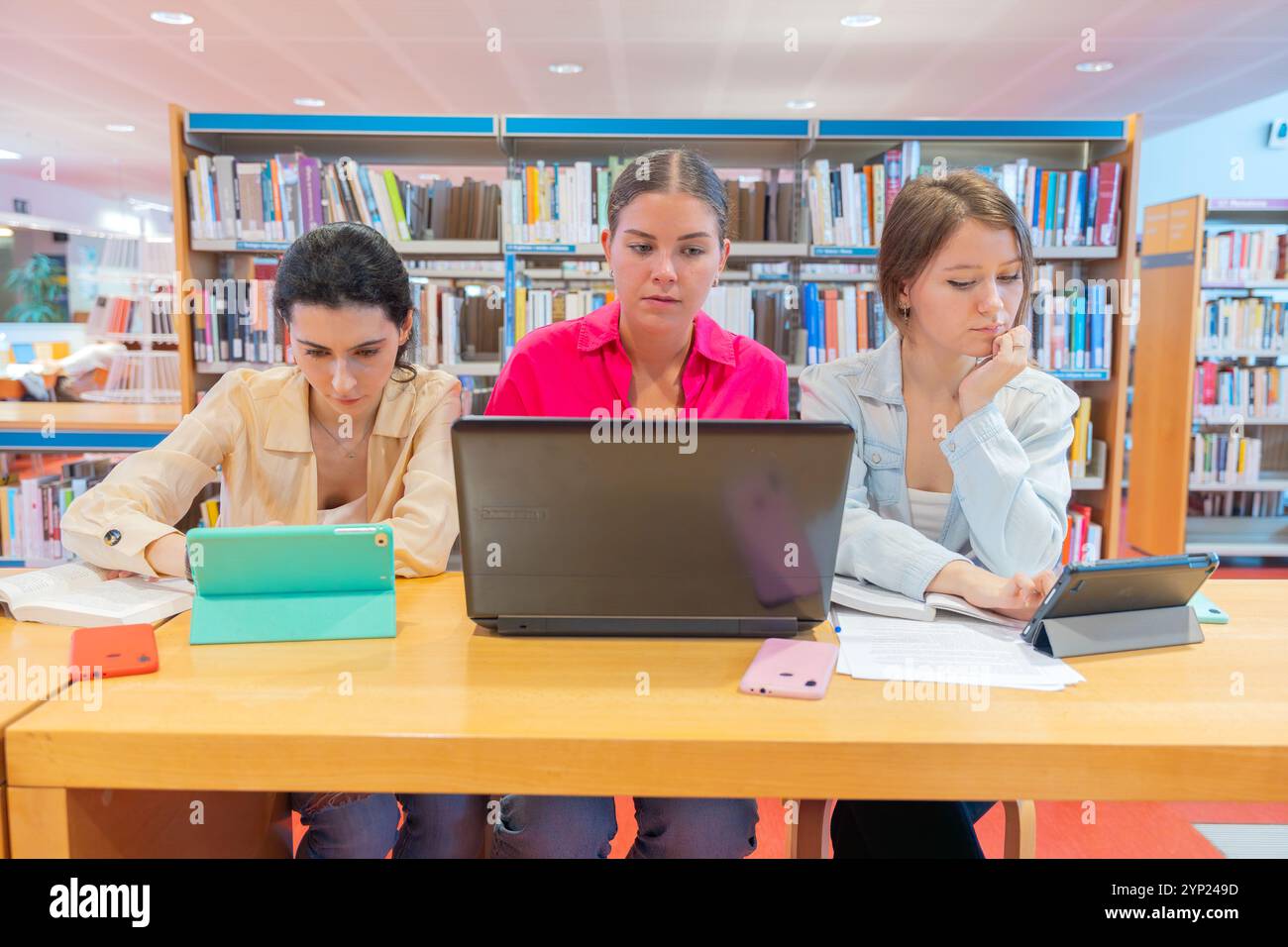 Students using laptops and tablets for study in library Stock Photo - Alamy