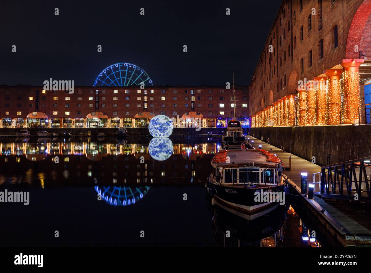 A stunning illuminated Earth installation reflecting on the water at ...