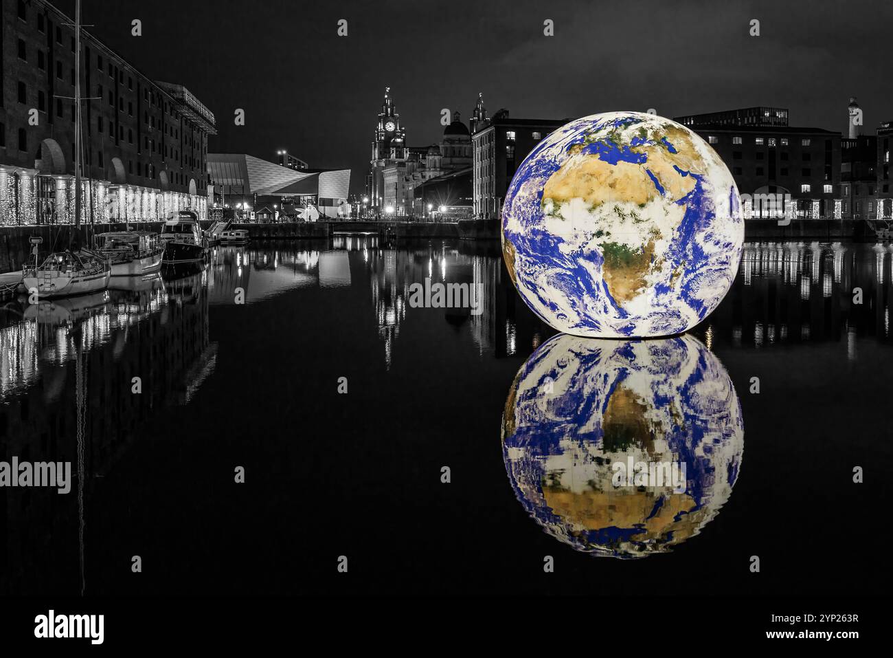 A stunning illuminated Earth installation reflecting on the water at ...