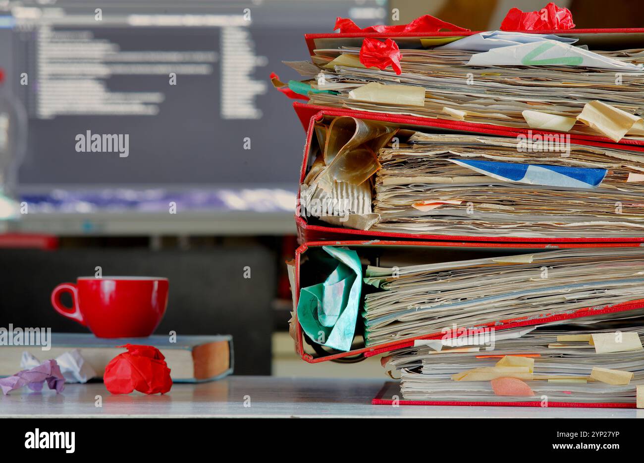 Heap of messy file folders,grungy paperwork,blurred office background ...