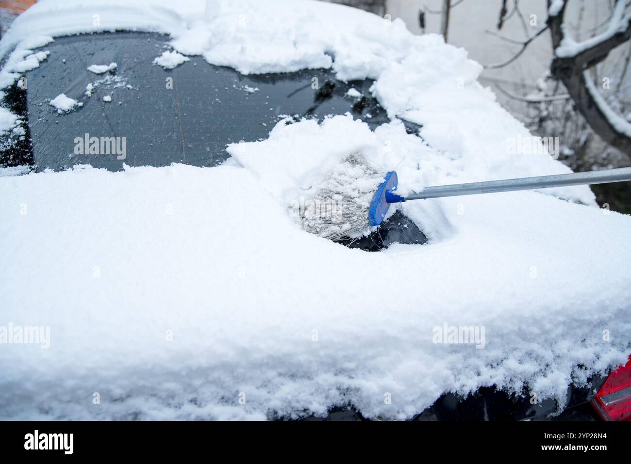 Snow covered car parked on street after snow storm. Side view of small ...