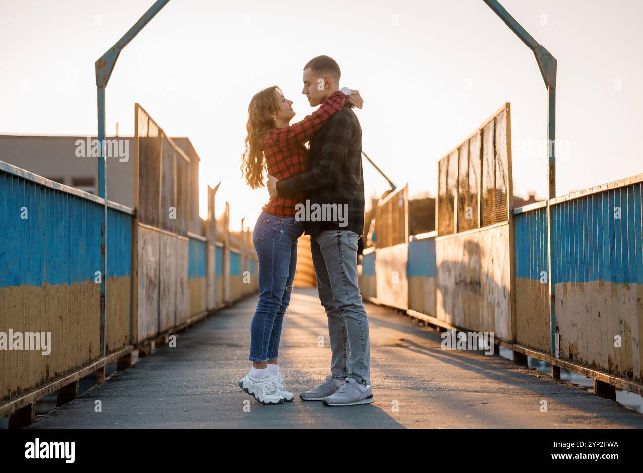 Romantic Sunset Embrace of a Young Couple on a Bridge Stock Photo - Alamy