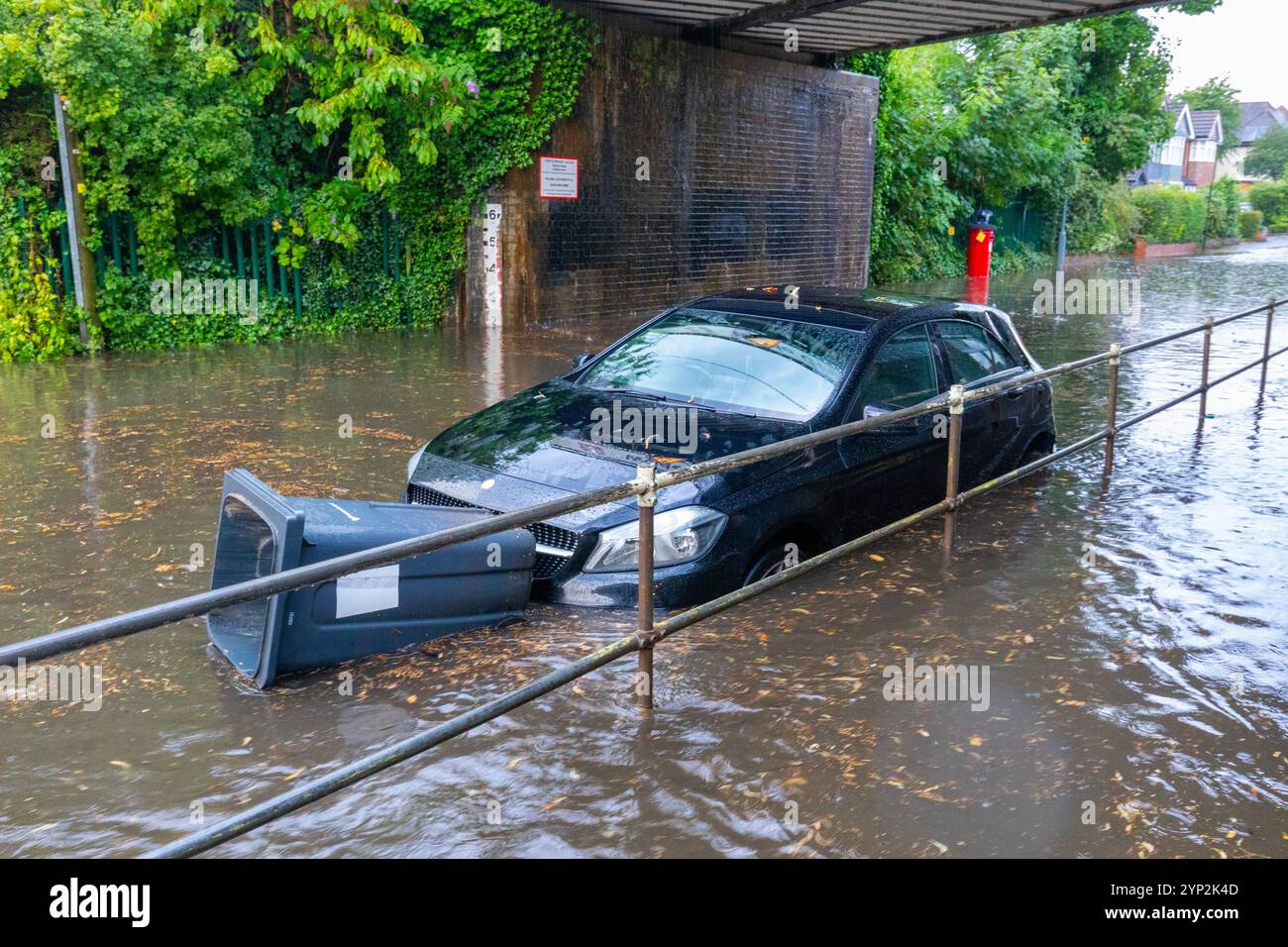 Flooded street with floating bin stuck in front of car, Sutton ...