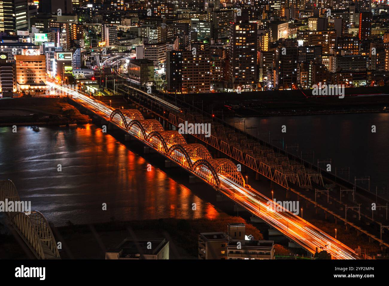 Traffic on bridges crossing the Yodo River and midnight night skyline ...