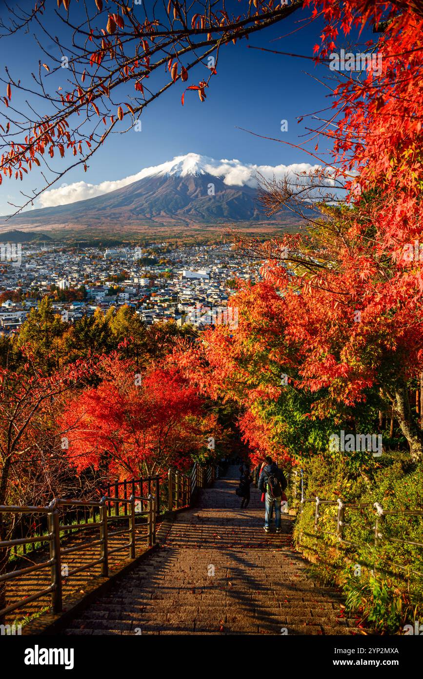View over the city of Fujiyoshida, Mount Fuji and maples leaves in autumn, Fujiyoshida, Honshu ...