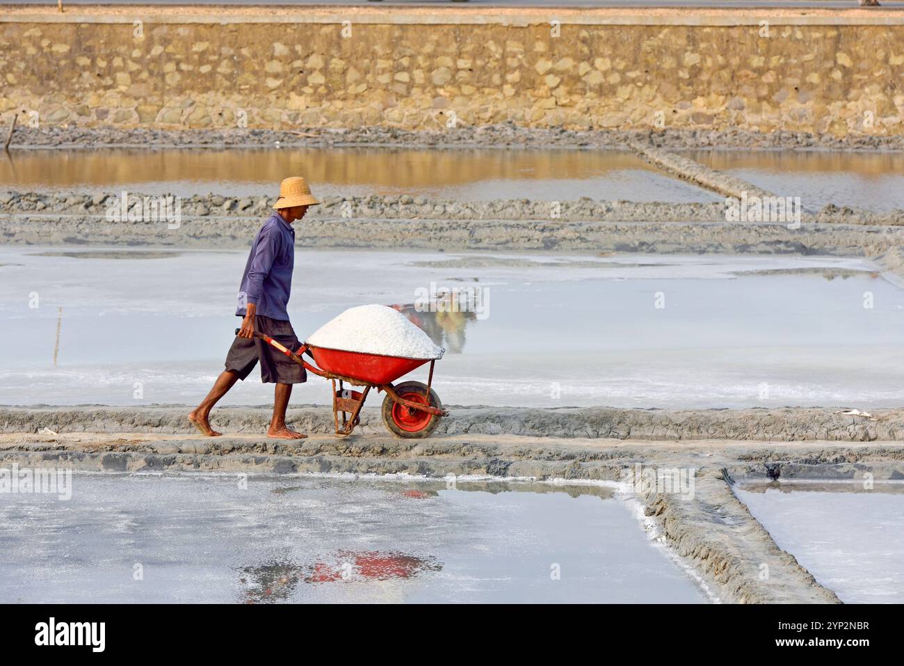 Worker pushing wheel barrow full of salt hi-res stock photography and ...