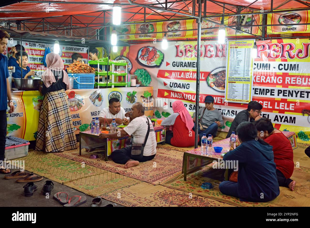 Open-air street side restaurant (lesehan) by night on Malioboro Street ...