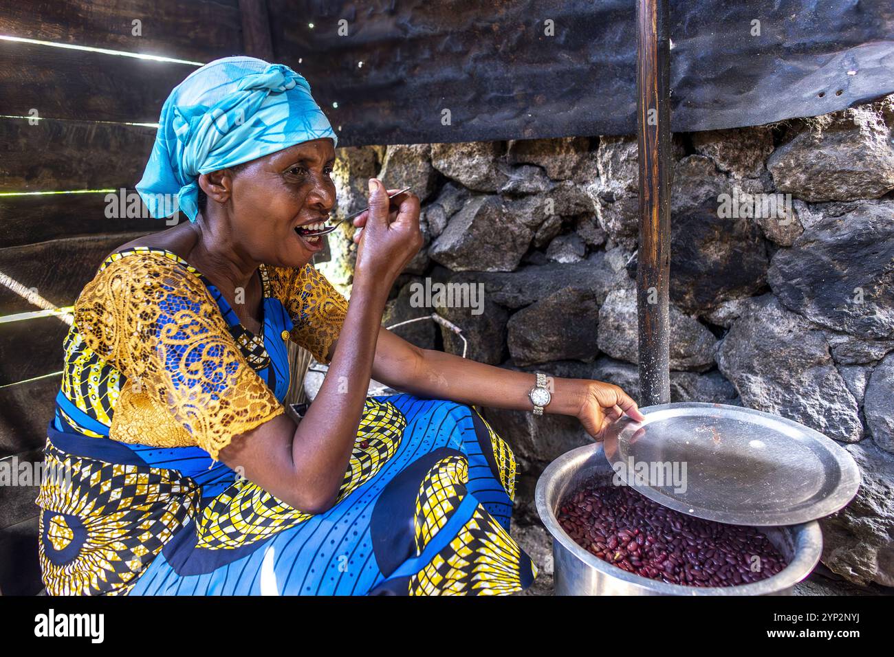 Woman tasting a dish in her kitchen in Bukavu, Democratic Republic of ...