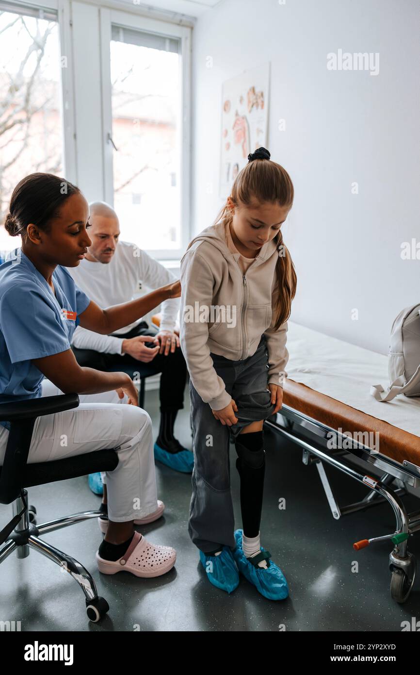 Girl with artificial limb standing next to female doctor in medical ...